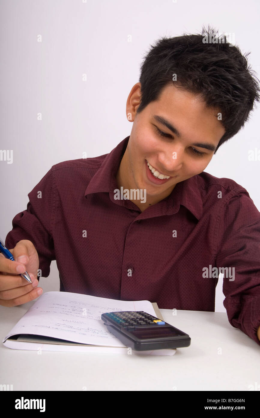 A young Asian American man doing his homework with a calculator Stock ...