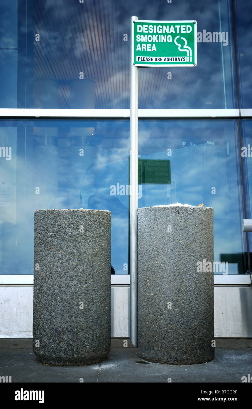 Outdoor designated smoking area with sign and ashtrays Stock Photo - Alamy