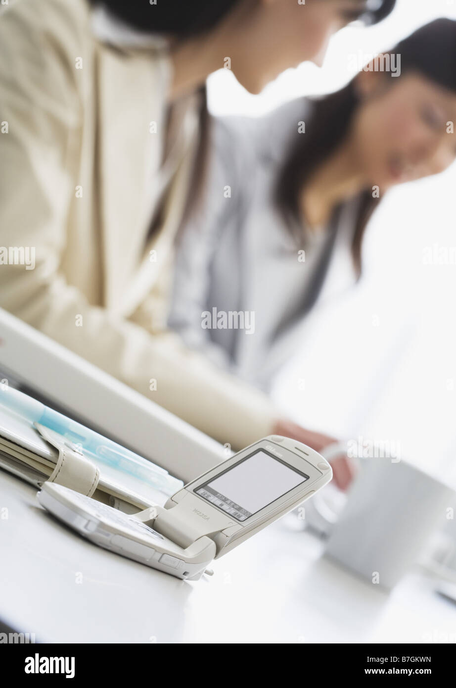 Cellular phone on the desk, businesswomen Stock Photo - Alamy