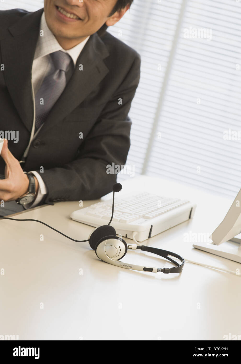 Businessman, a headset on the desk Stock Photo - Alamy