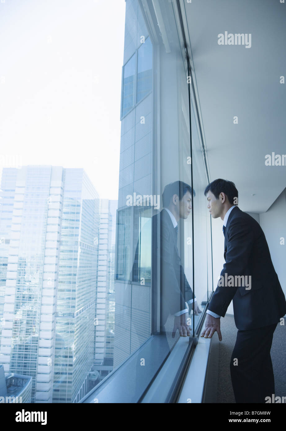 Businessman looking out window Stock Photo - Alamy