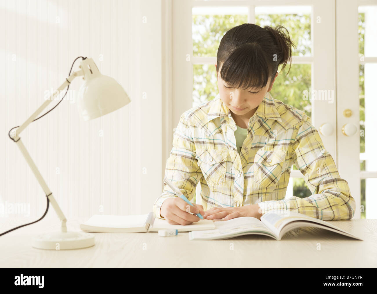 Girl studying at the desk Stock Photo - Alamy