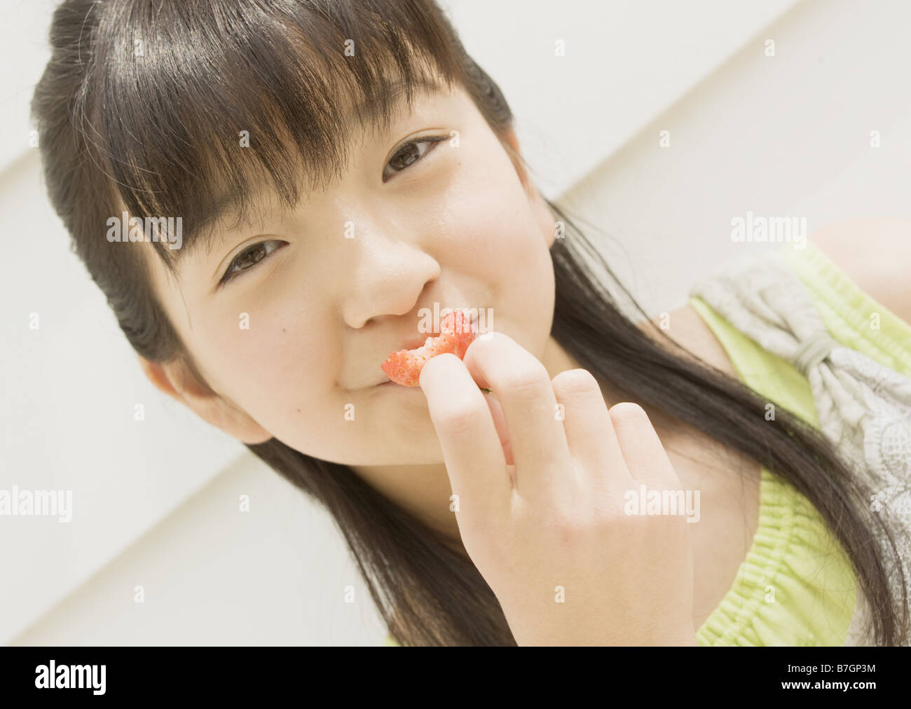 Girl eating a strawberry outside Stock Photo - Alamy
