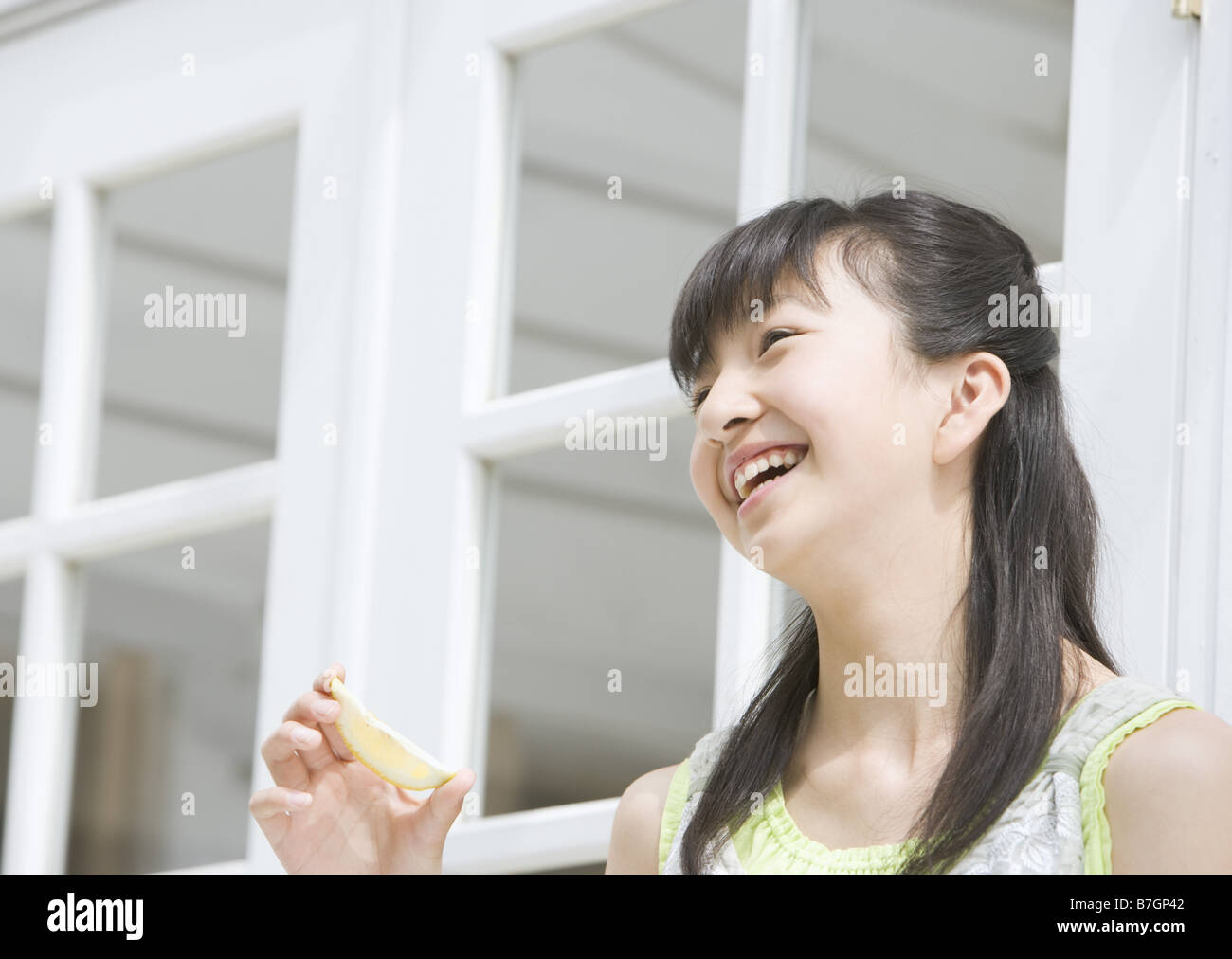 Smiling girl having a piece of lemon outside Stock Photo - Alamy