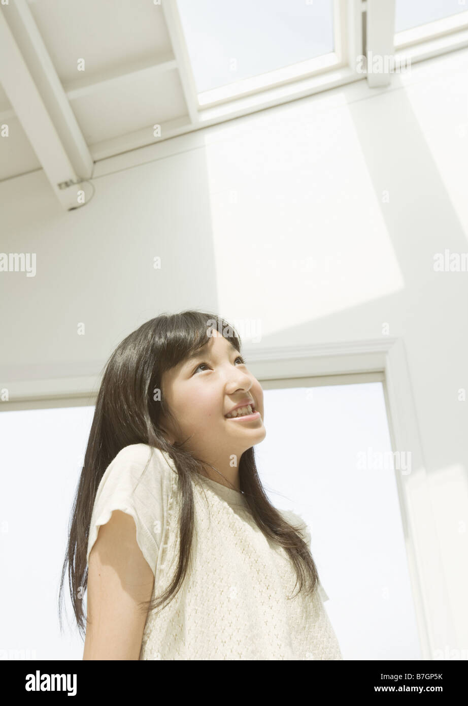 Girl looking up something in the room Stock Photo - Alamy