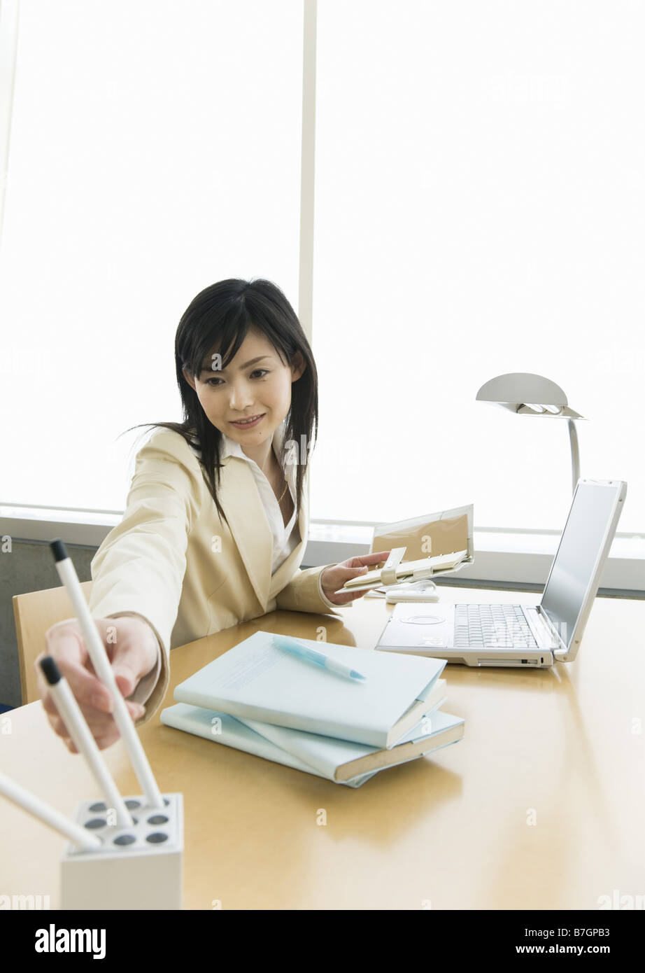 Businesswoman picking a pen up Stock Photo - Alamy