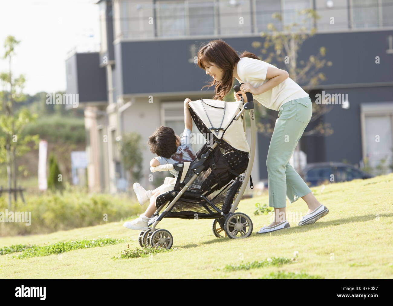 Mother pushing baby buggy Stock Photo - Alamy