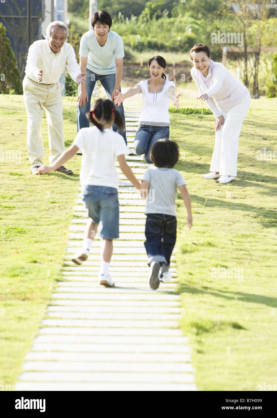 Running children and family Stock Photo - Alamy
