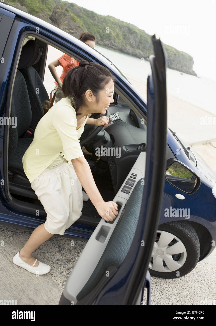 Two women getting out of a car Stock Photo - Alamy