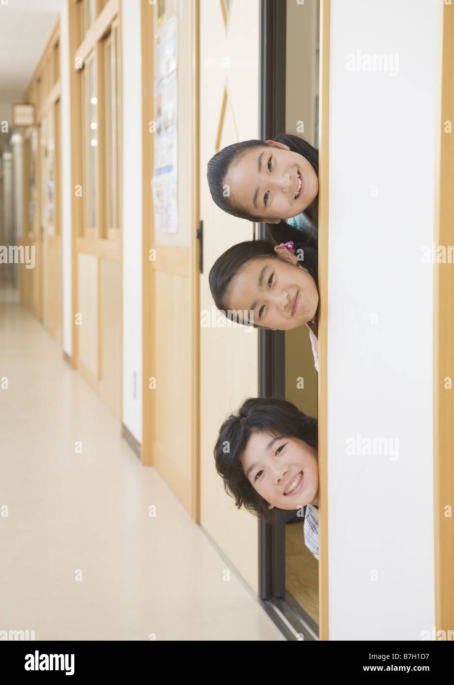 Elementary school students peeking through the door Stock Photo - Alamy