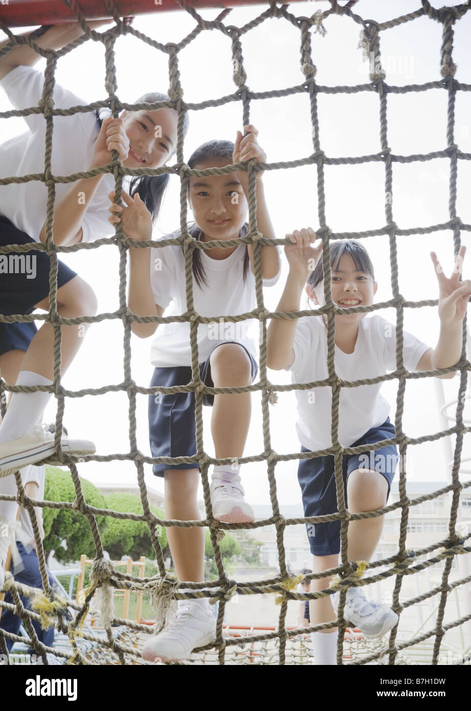 Elementary students climbing play equipment Stock Photo - Alamy