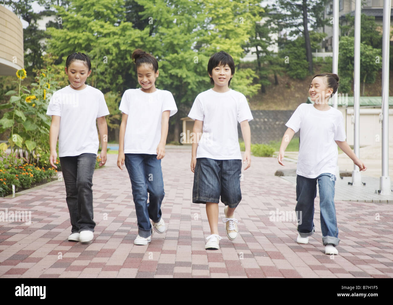Elementary school students walking on schoolyard Stock Photo - Alamy