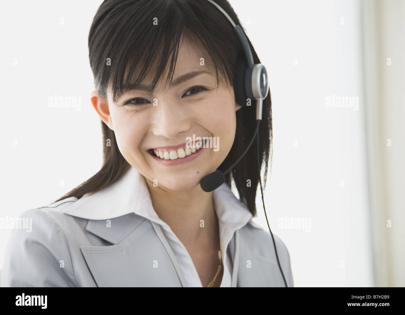 Smiling operator wearing a headphone in the office Stock Photo - Alamy