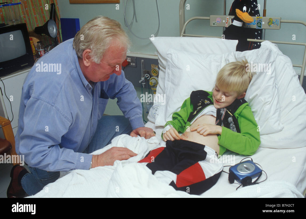 child in hospital showing his grandfather his stitches after his ...