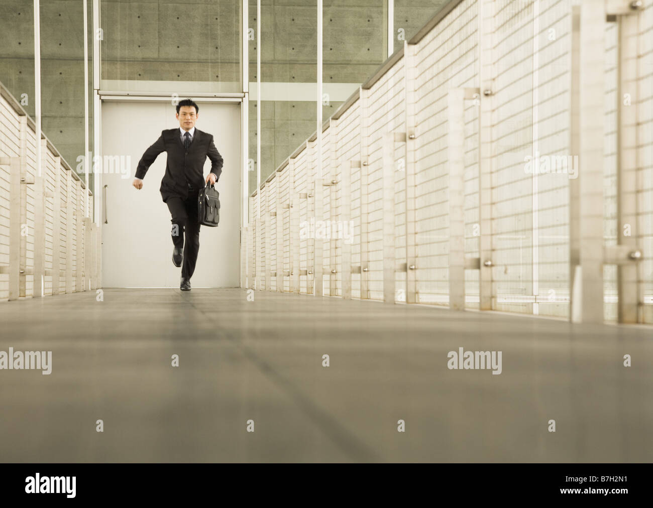 Businessman running on walkway Stock Photo - Alamy