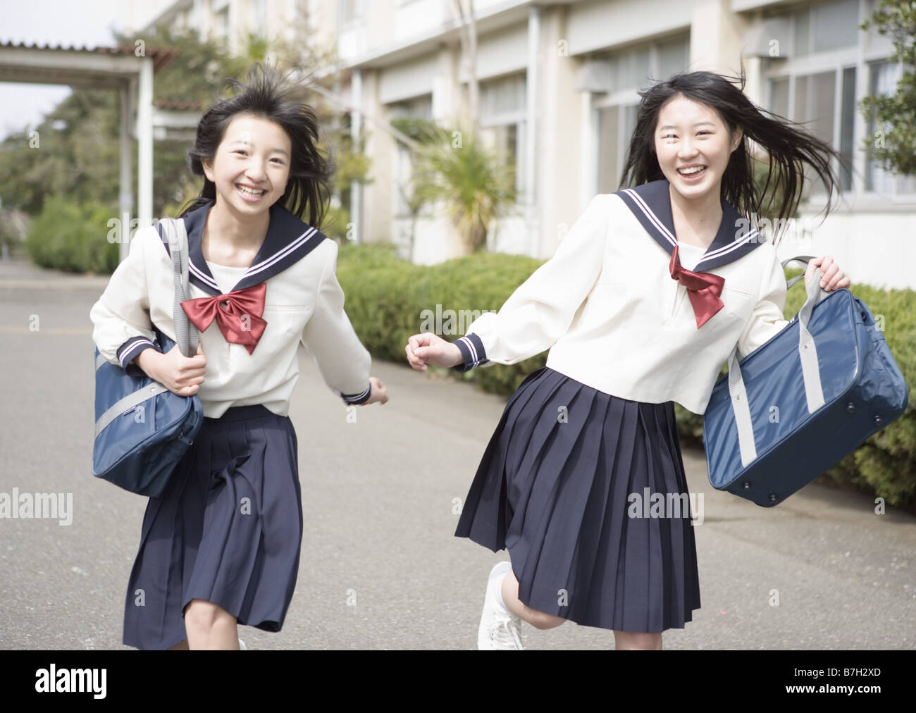 Teenagegirls in school uniforms running to school Stock Photo - Alamy