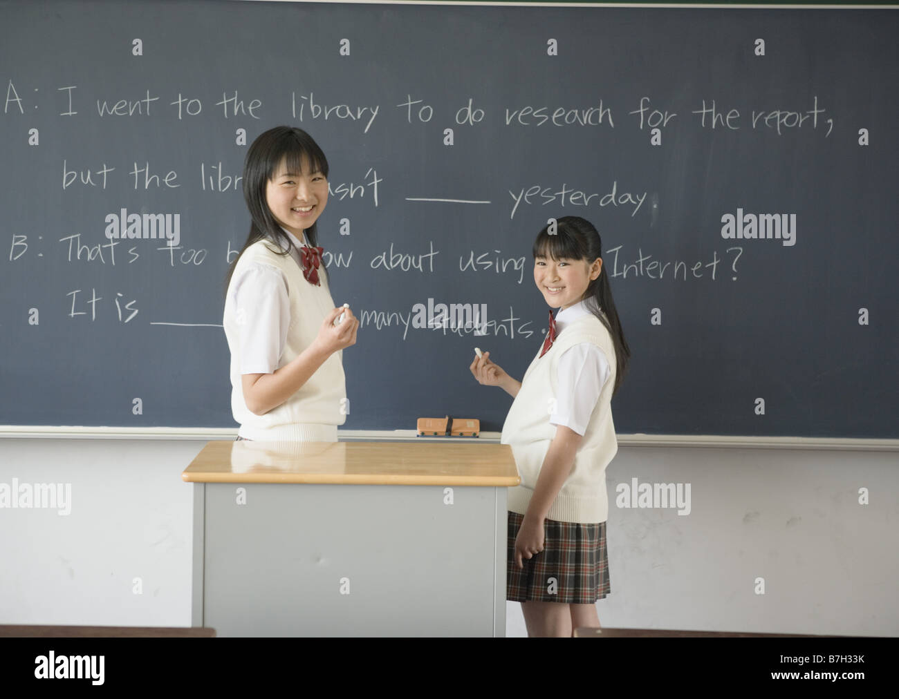 Students writing on chalkboard Stock Photo - Alamy