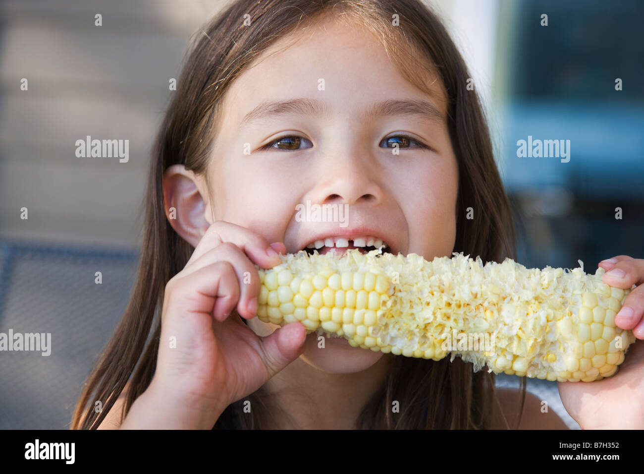 Asian girl eating corn on the cob Stock Photo - Alamy