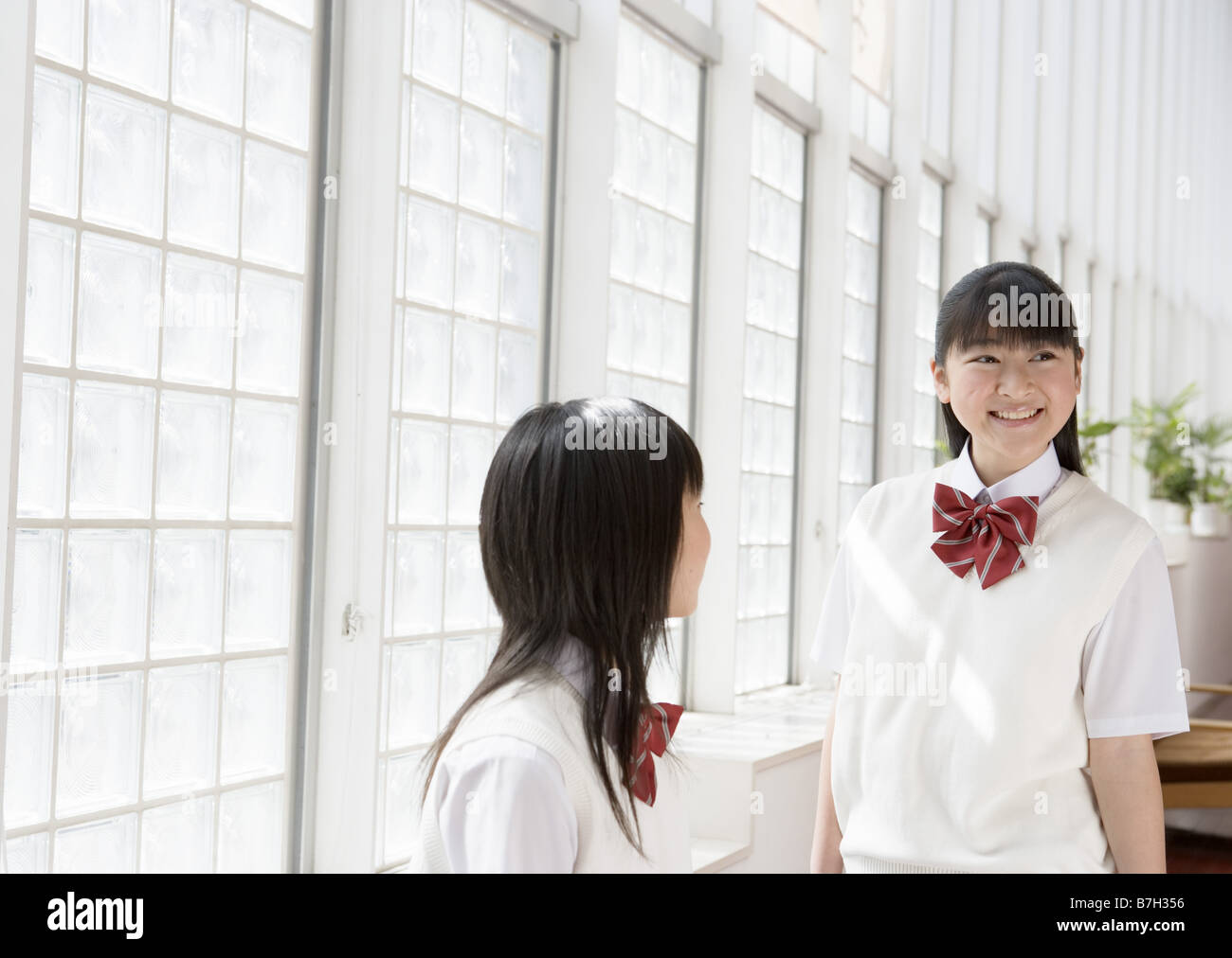 Teenagers talking by window Stock Photo - Alamy