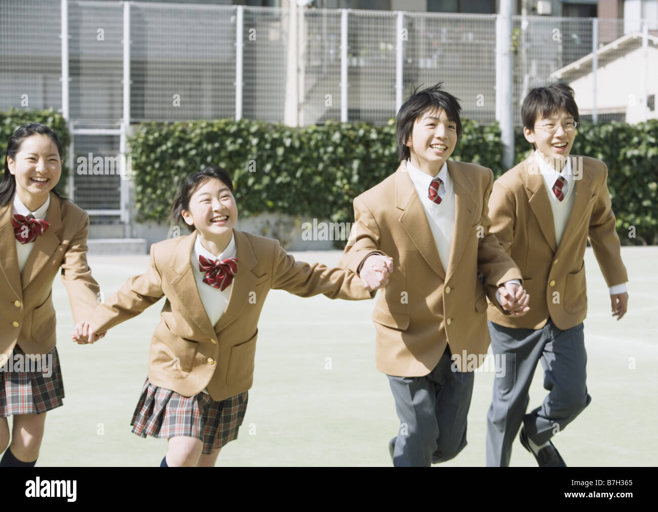 Group of students running in athletic field Stock Photo - Alamy