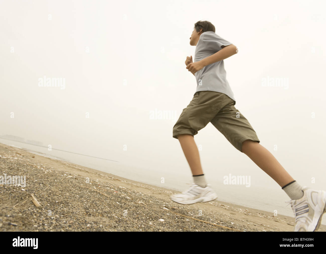 Boy running along the beach Stock Photo - Alamy