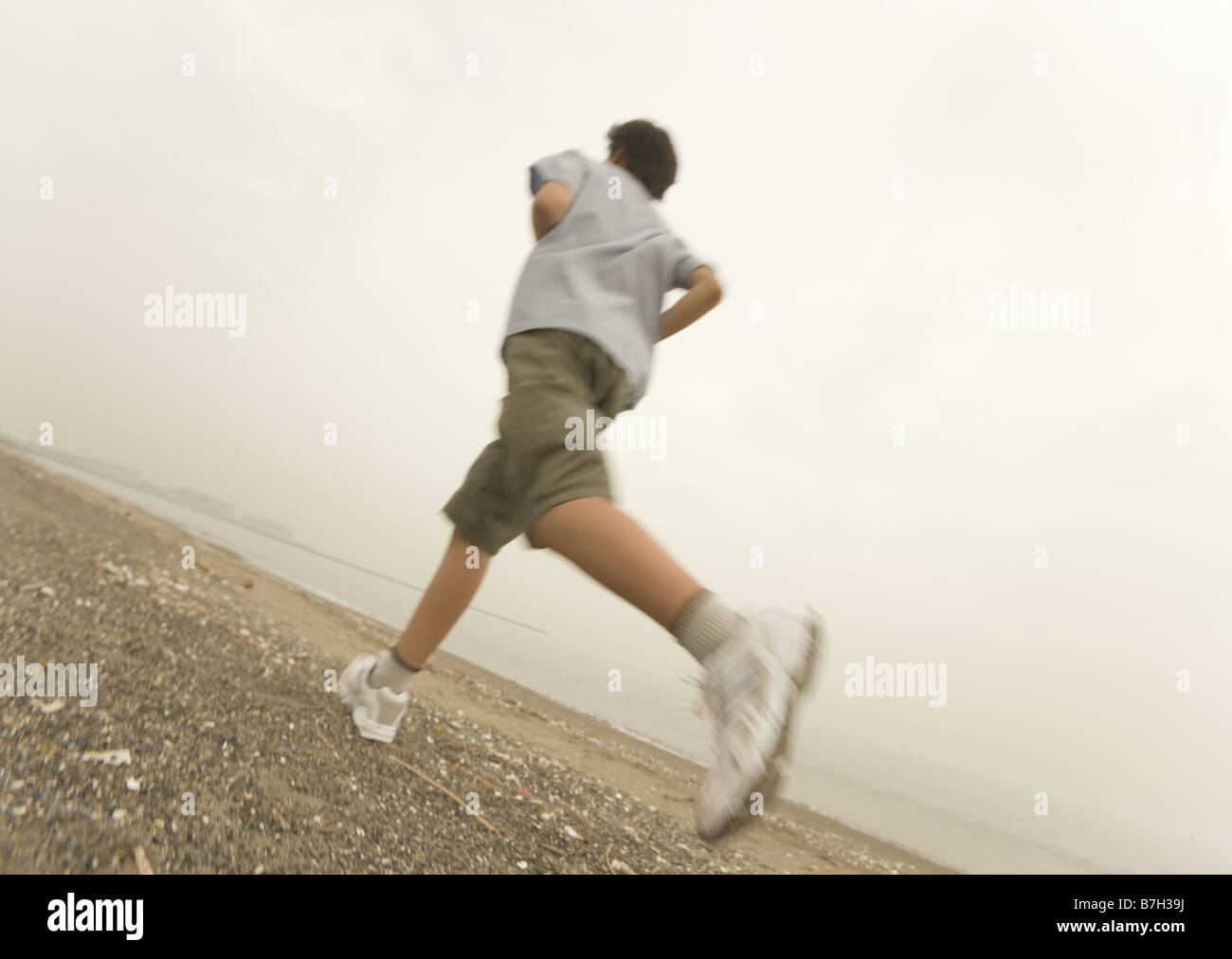 Boy running along the beach Stock Photo - Alamy