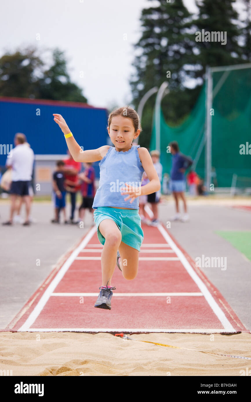 Asian girl performing long jump Stock Photo - Alamy
