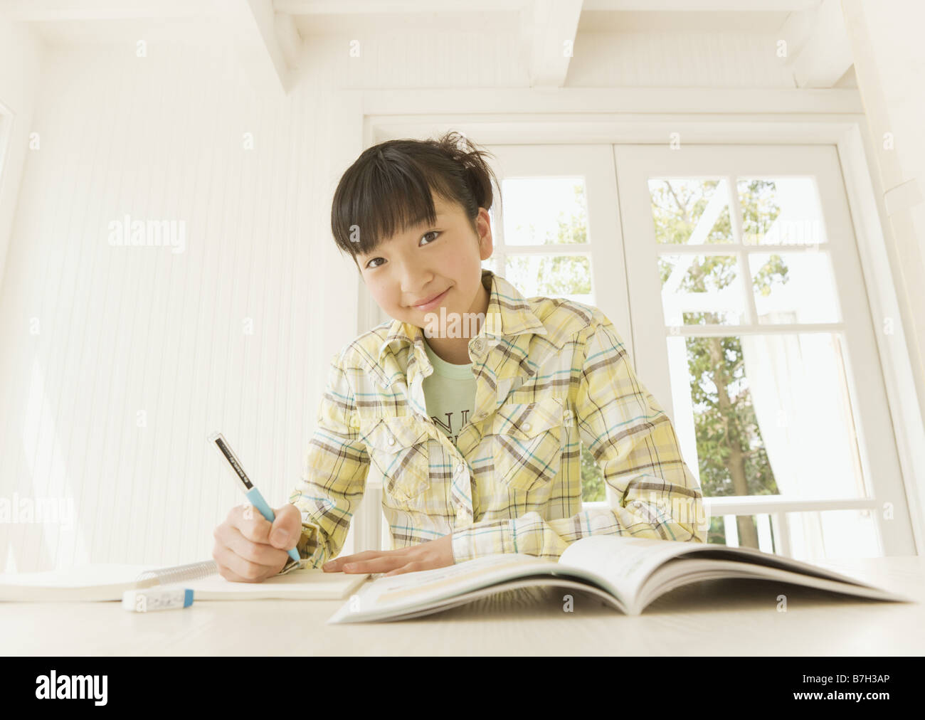 Girl doing homework at the desk Stock Photo - Alamy
