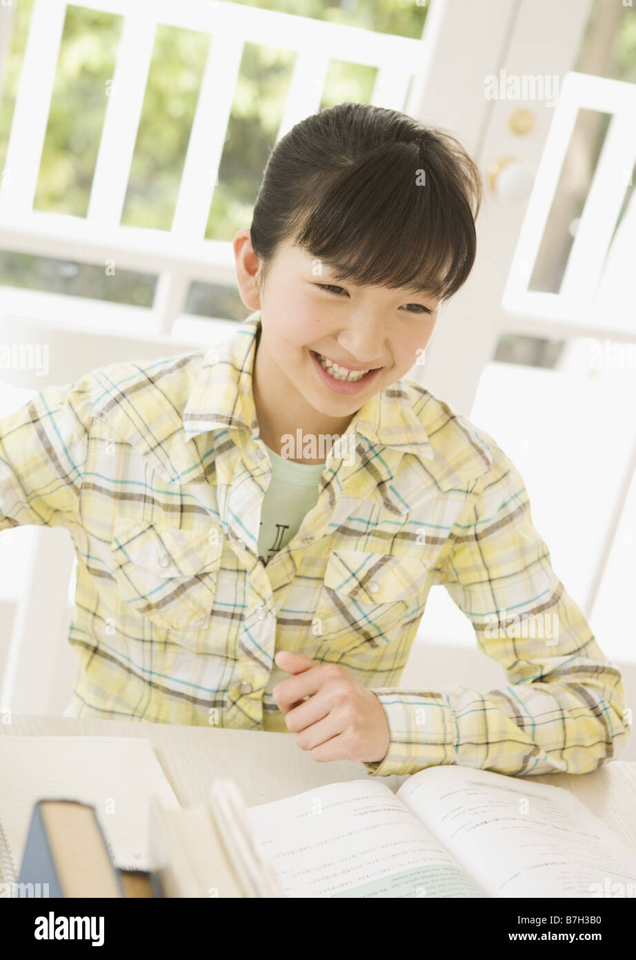 Smiling girl studying by herself in the room Stock Photo - Alamy