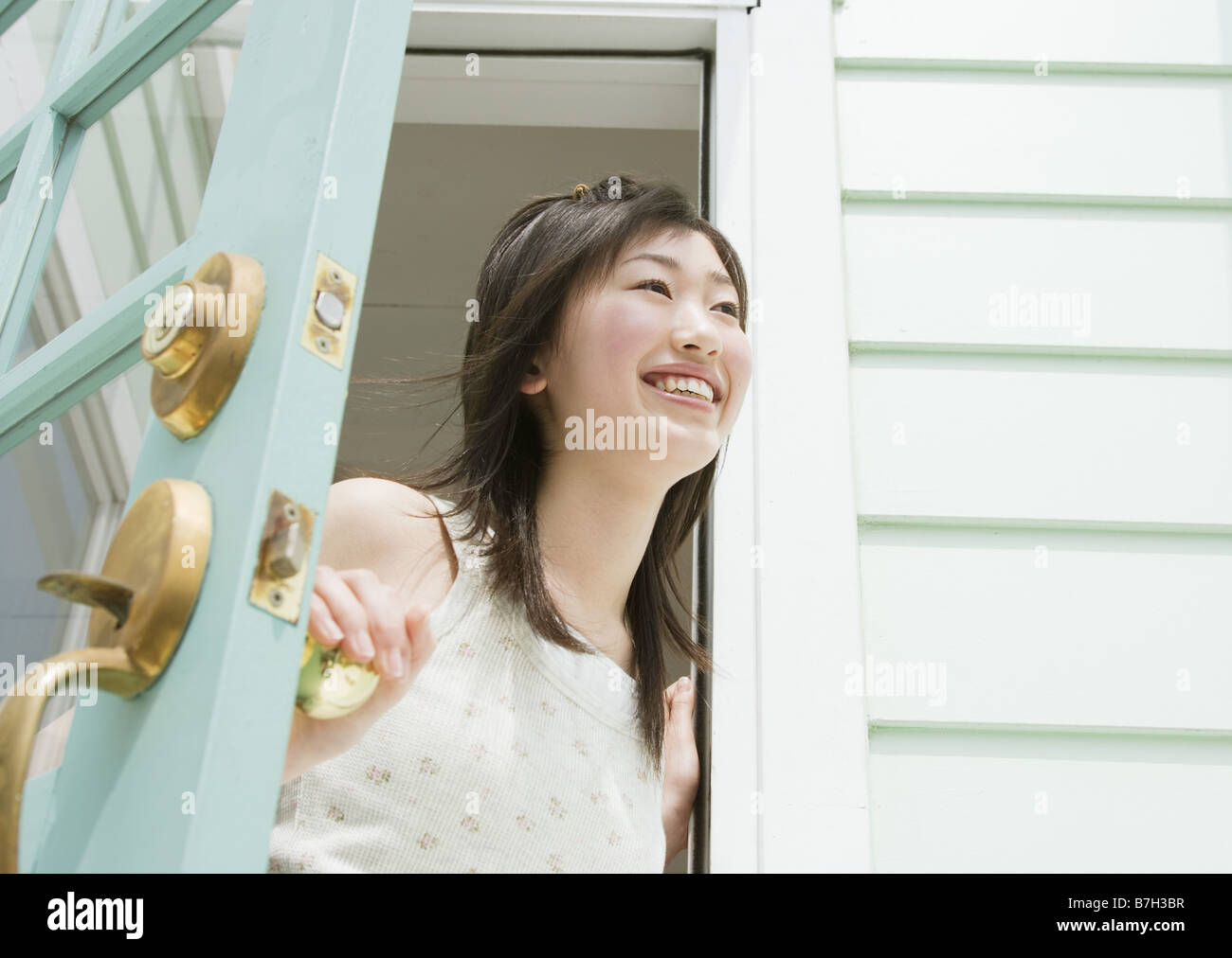 Smiling girl opening the door Stock Photo - Alamy