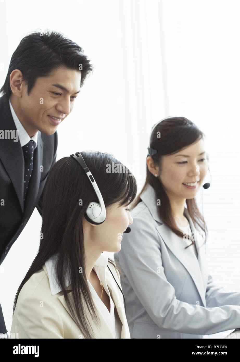 Operators and a businessman talking together Stock Photo - Alamy