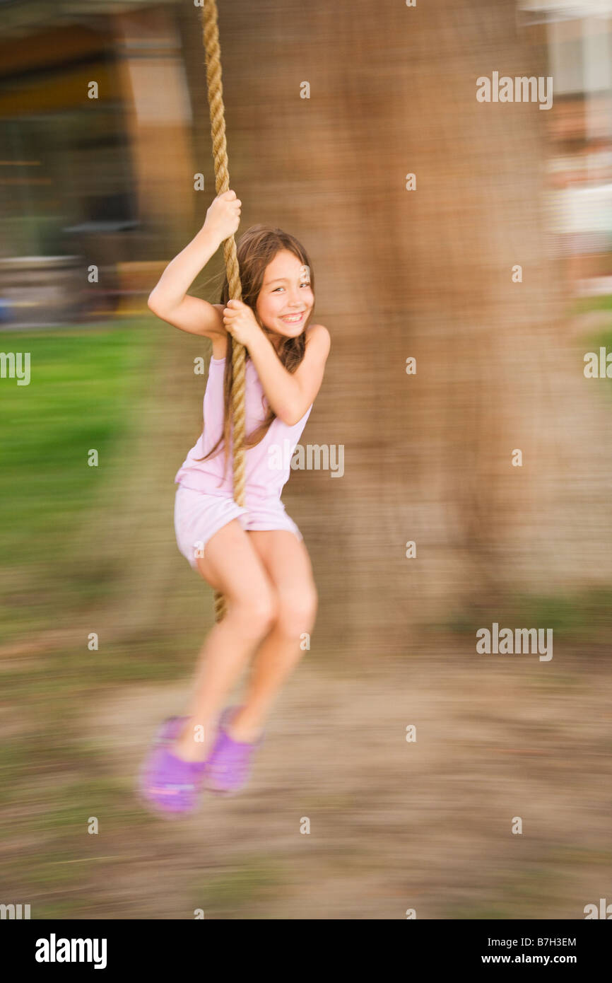 Asian girl swinging on rope swing Stock Photo - Alamy