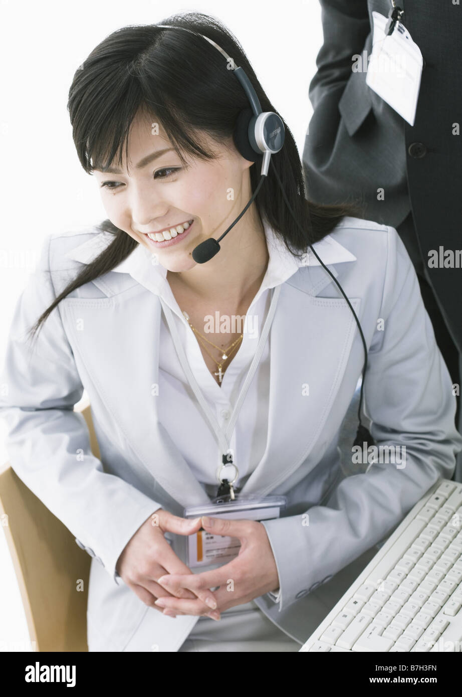 Smiling operator putting on a headphone Stock Photo - Alamy