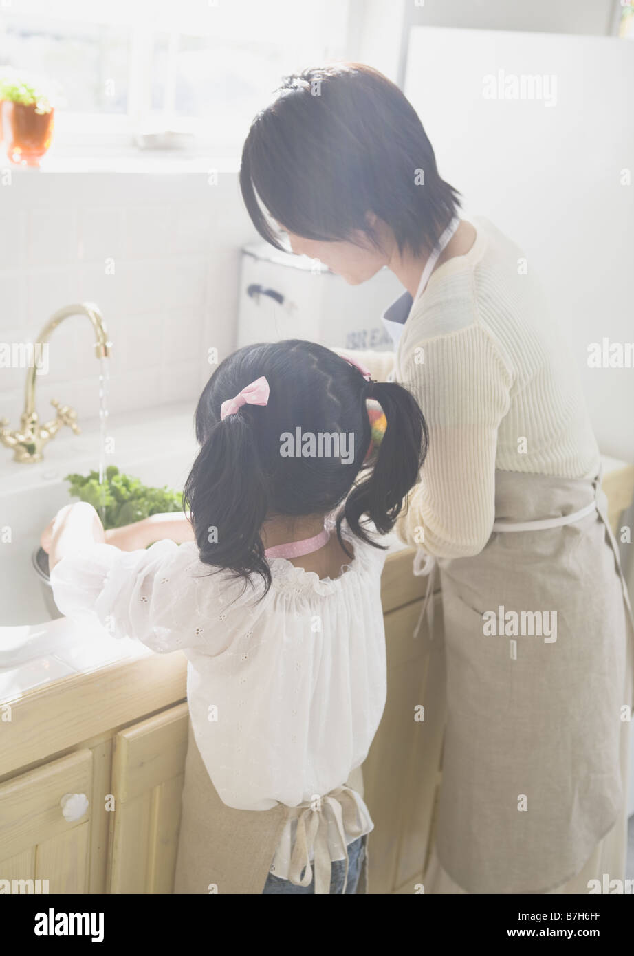 Child helping parent wash dishes hi-res stock photography and images - Alamy