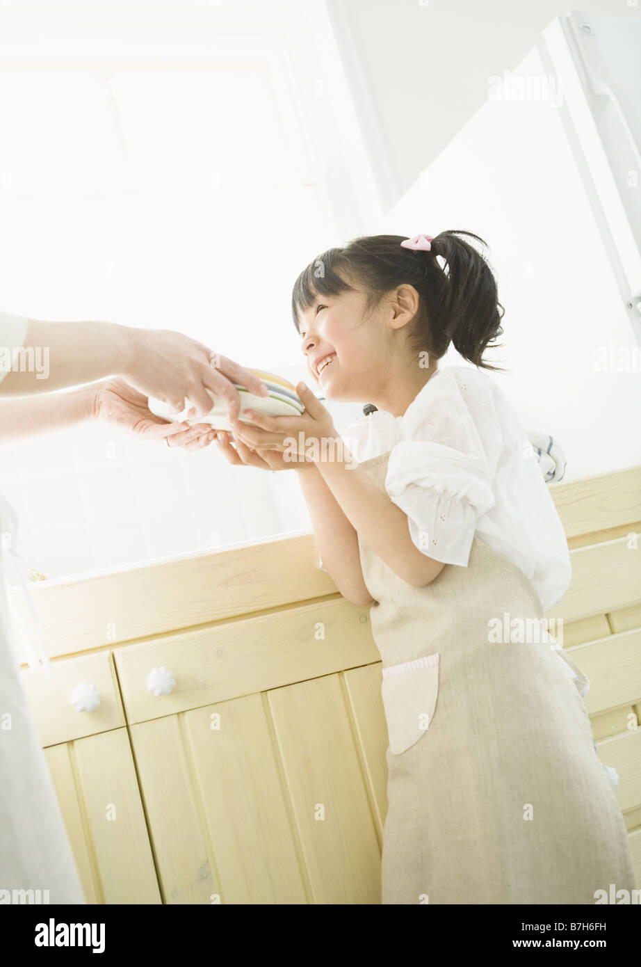 Girl Helping Mother Wash Dishes Stock Photo - Alamy