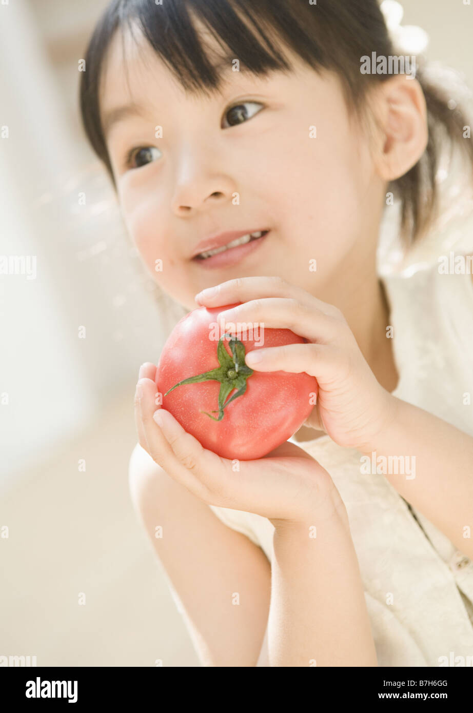 Girl Holding a Tomato Stock Photo - Alamy