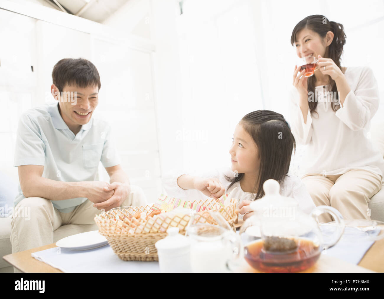 Girl Having Snacks with Parents Stock Photo - Alamy