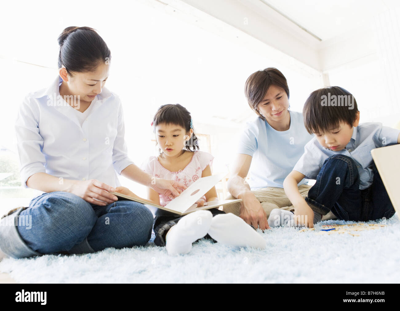 Parents Reading a Book for Children Stock Photo - Alamy