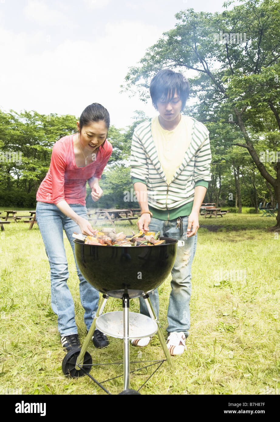 Young people barbecuing Stock Photo - Alamy