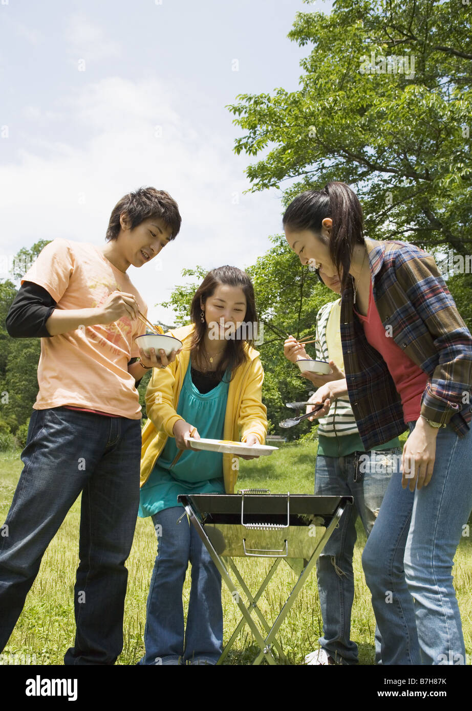 Young people barbecuing Stock Photo - Alamy