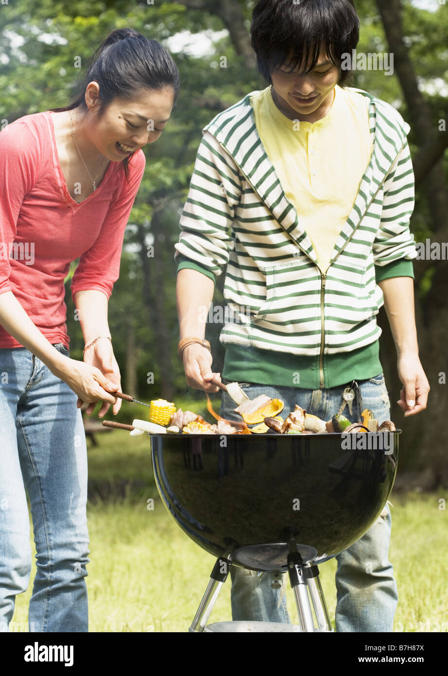 Young people barbecuing Stock Photo - Alamy
