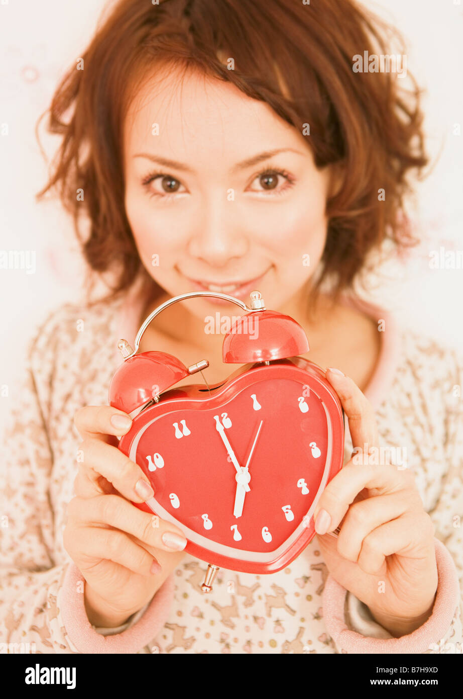 A woman holding alarm clock Stock Photo - Alamy