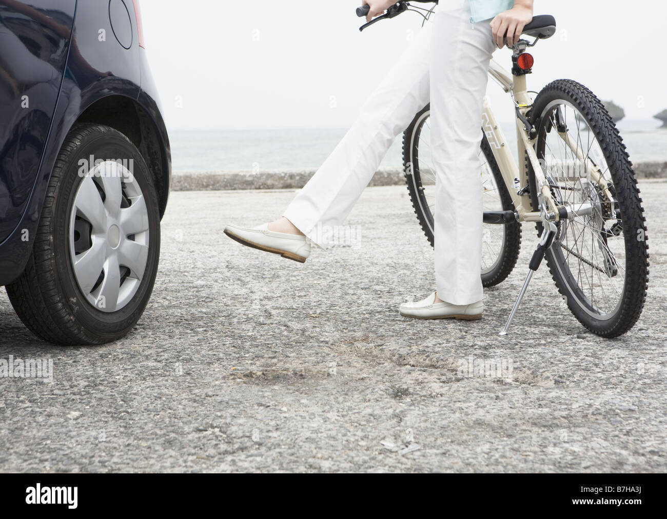 A woman leaning against bicycle Stock Photo - Alamy