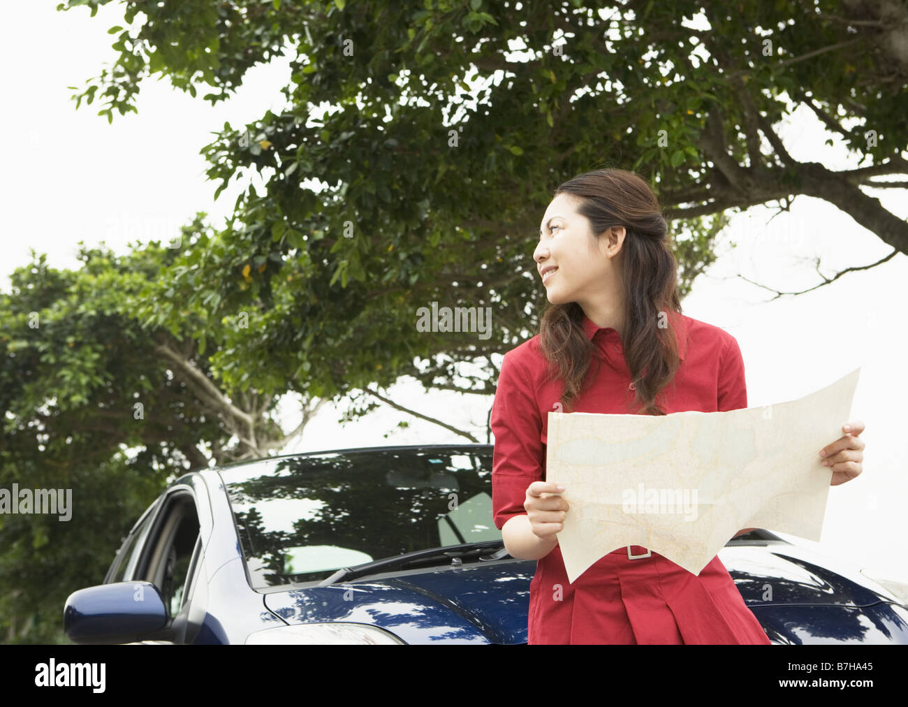 A woman opening out a map Stock Photo - Alamy
