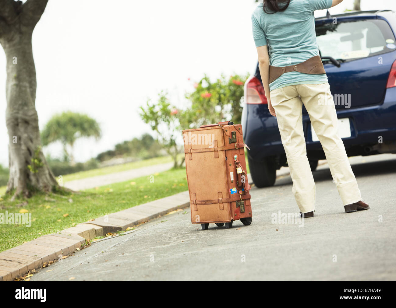 Woman with a suitcase by a car Stock Photo - Alamy