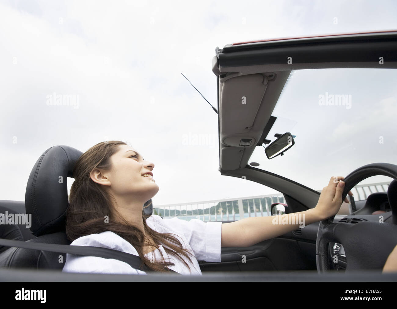 A young woman driving convertible Stock Photo - Alamy