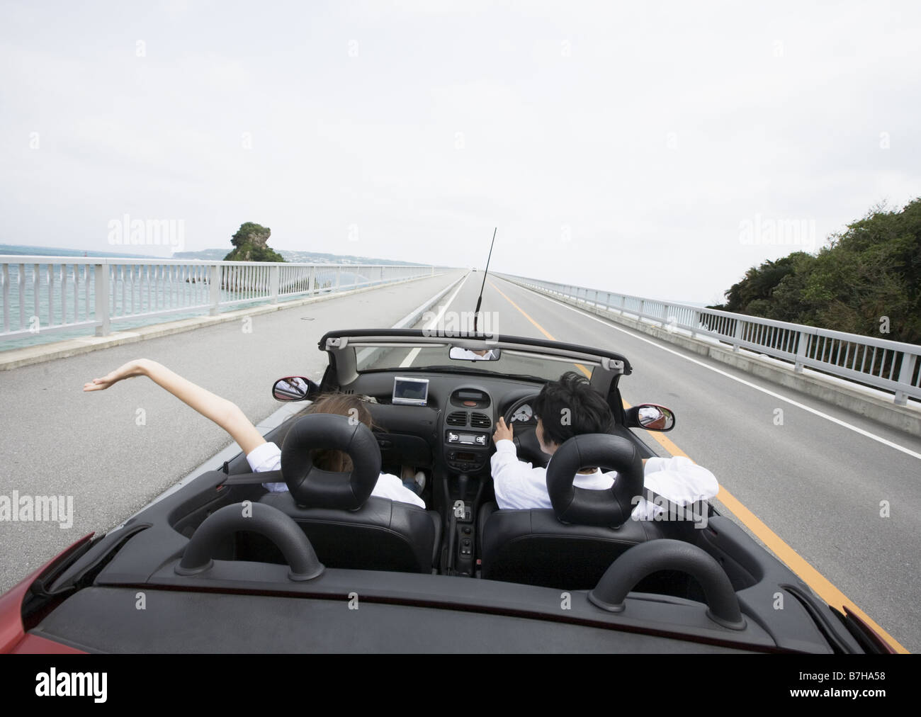 Back shot of couple driving a convertible Stock Photo - Alamy