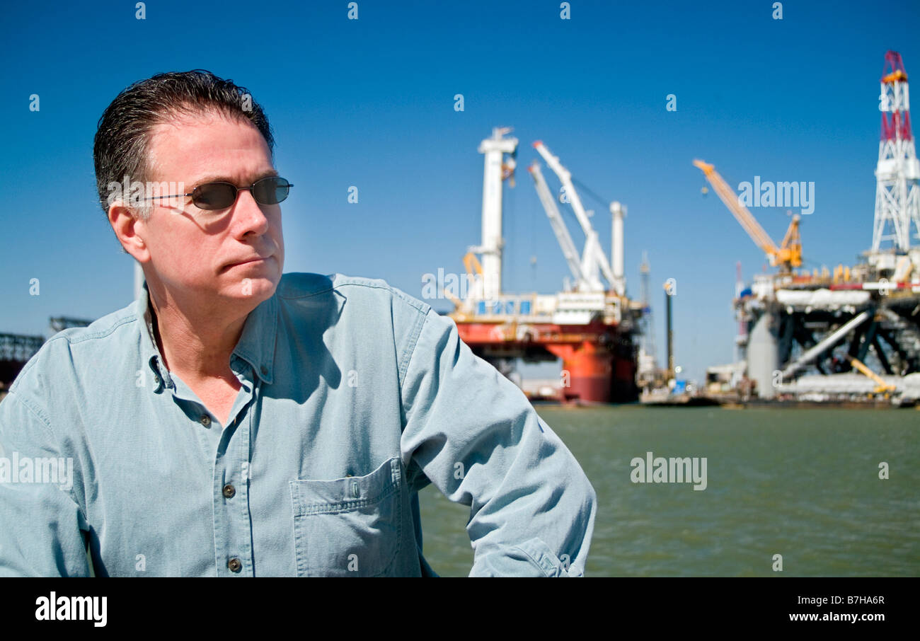 A man with drilling rigs in the background Stock Photo - Alamy