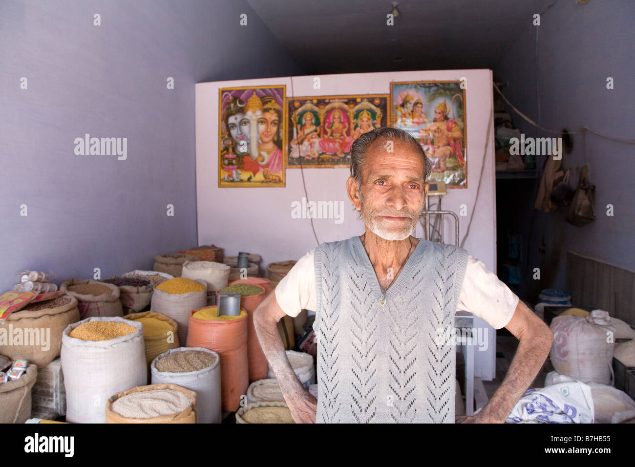 Grey bearded Indian man standing with hands on hips in spice shop ...