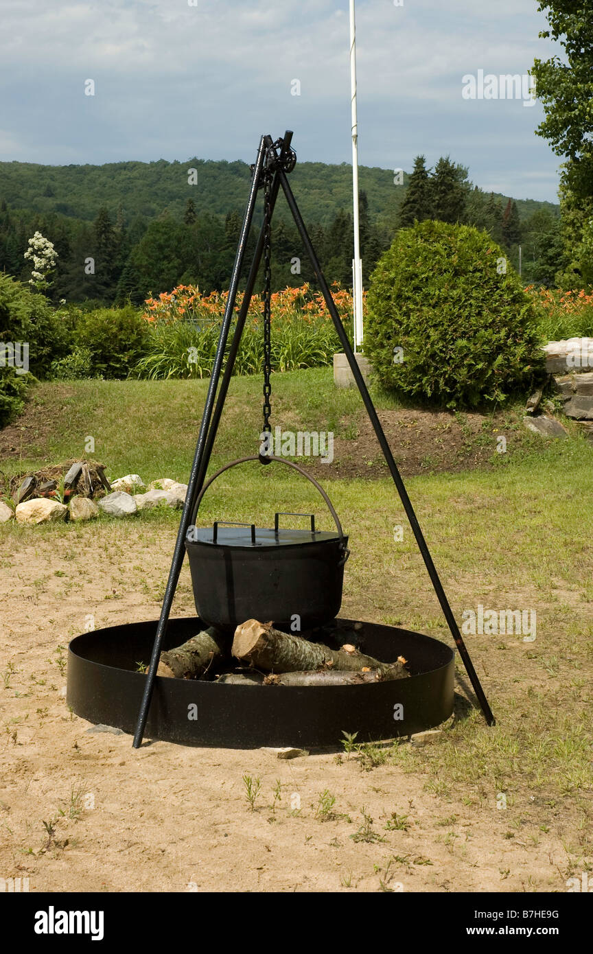 big iron cooking pot on the beach over campfire ready to cook beans or ...